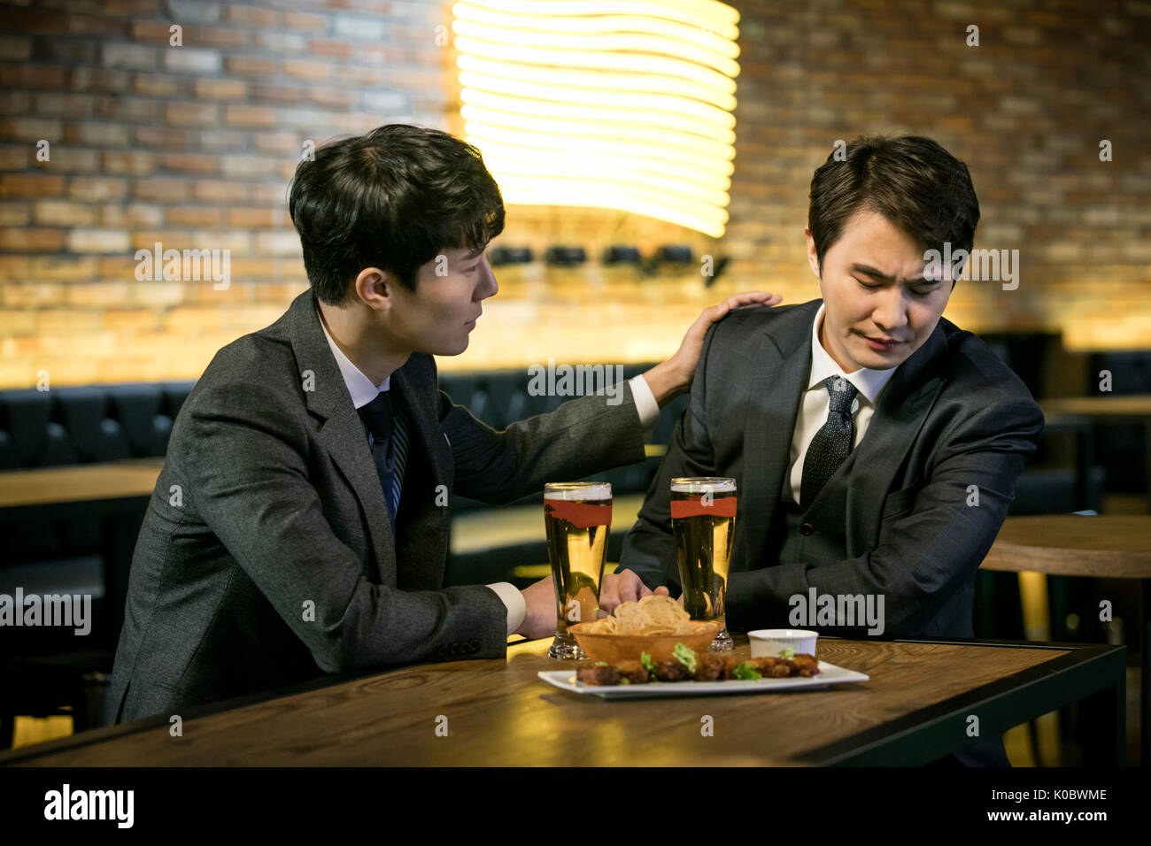 Two businessmen worried drinking at bar Stock Photo - Alamy