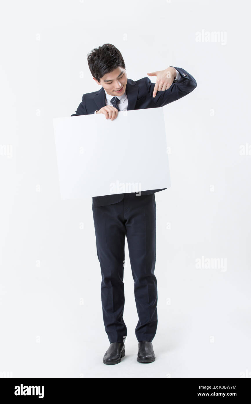 Young smiling businessman showing a placard Stock Photo - Alamy