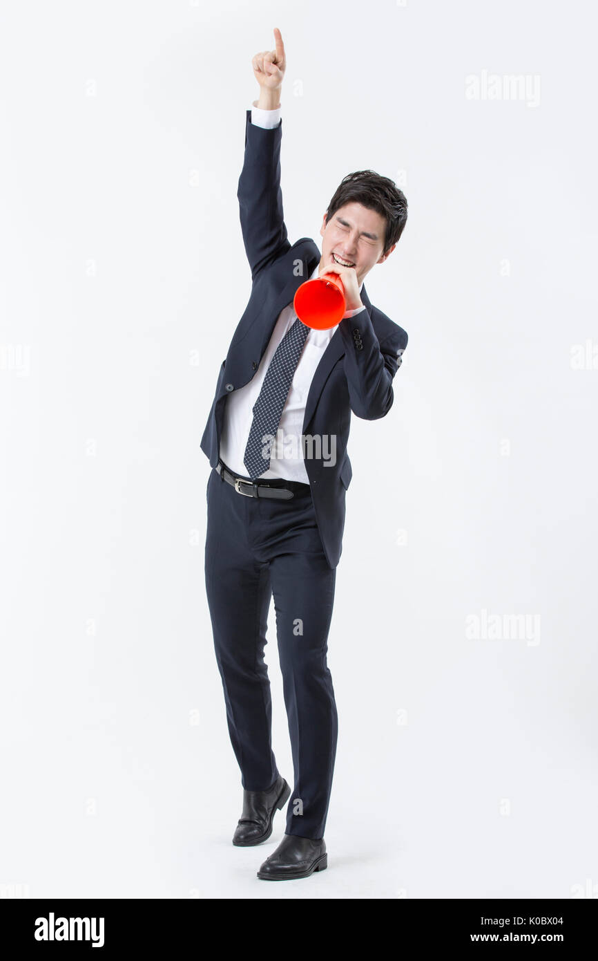 Young smiling businessman with megaphone standing pointing up Stock ...