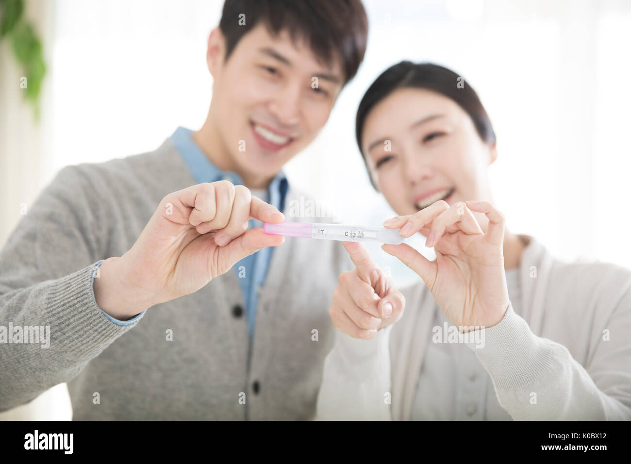 Portrait of smiling couple doing pregnancy test Stock Photo - Alamy