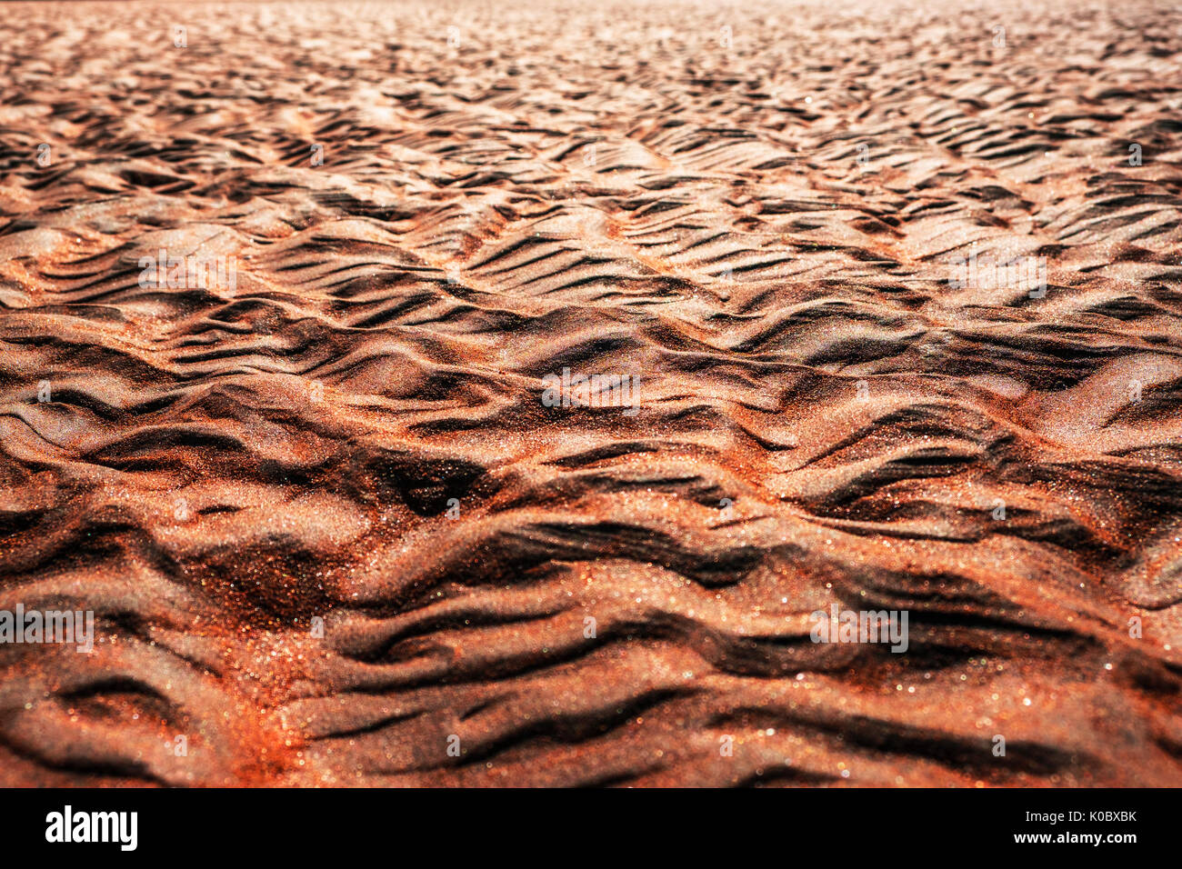 Close up of sand of a beach - alien landscape, akin to mars, red, gold ...