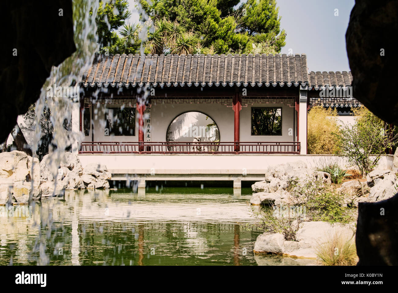 Chinese Building seen through a cave and waterfall Stock Photo - Alamy