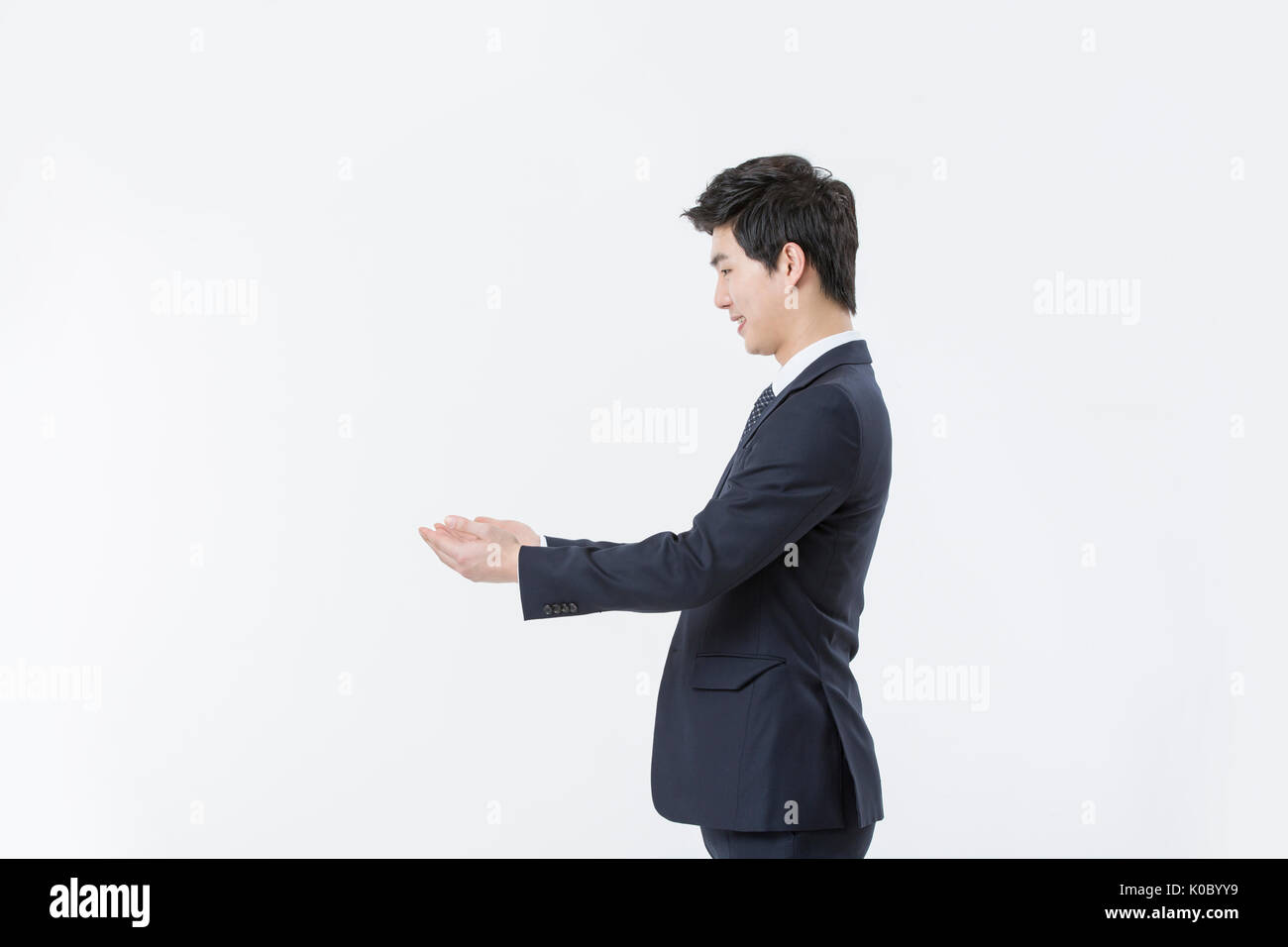 Side view of young businessman in suit holding hands Stock Photo - Alamy