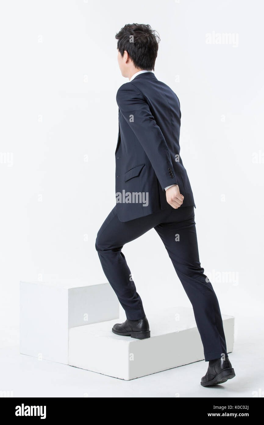 Side view of young businessman in suit going upstairs Stock Photo - Alamy