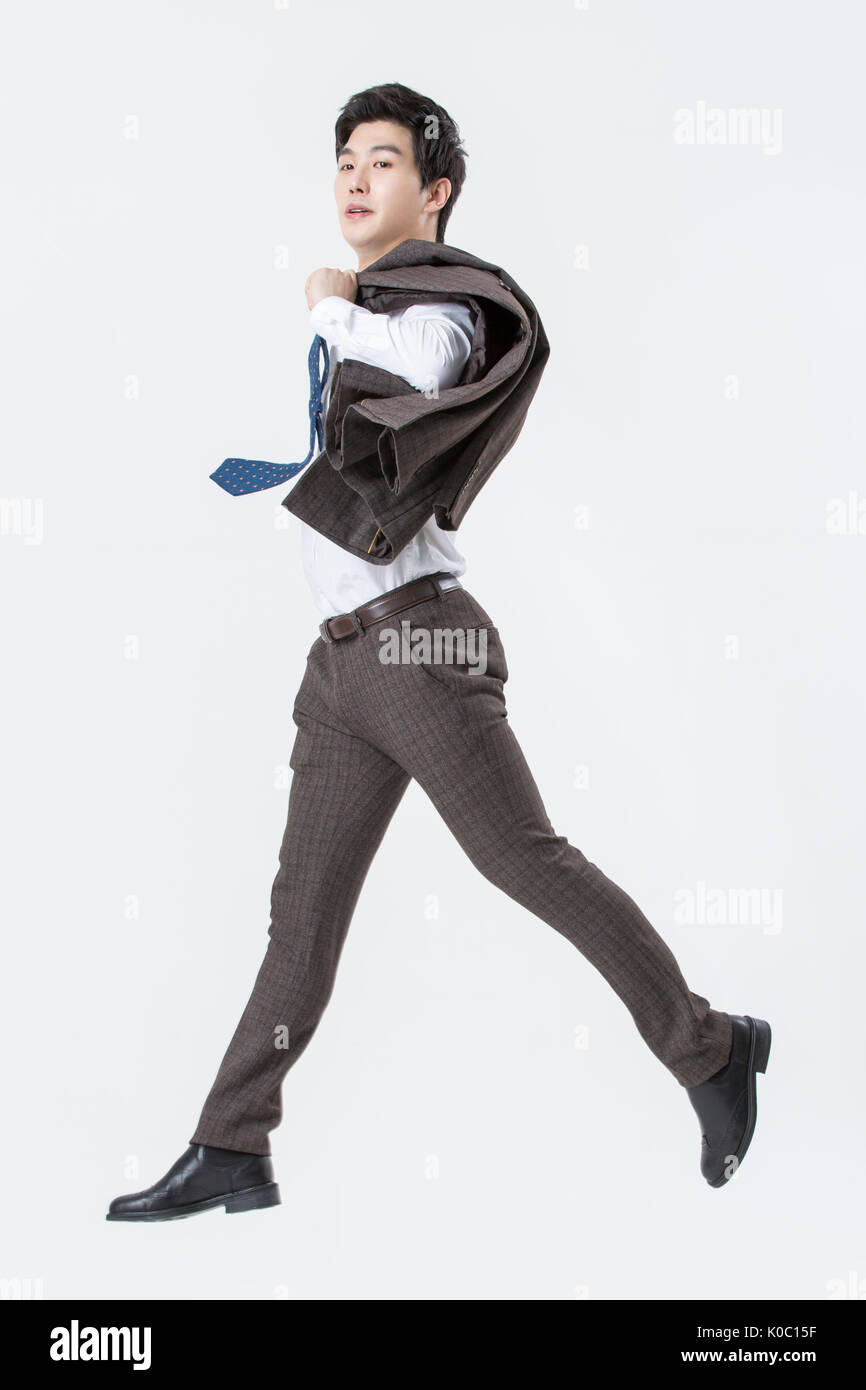 Side view of young man in suit jumping Stock Photo - Alamy