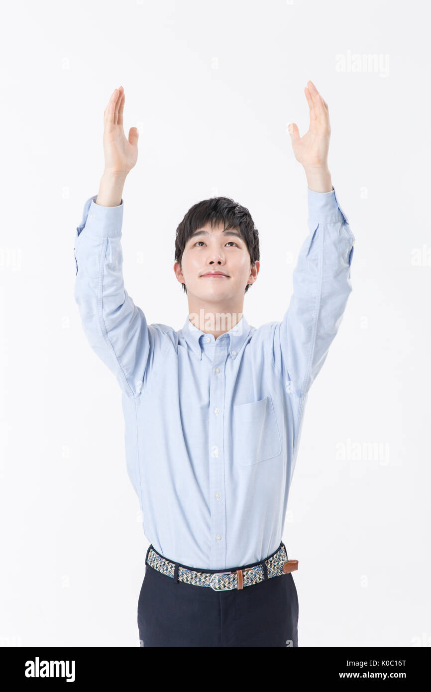 Young man holding hands looking up Stock Photo - Alamy