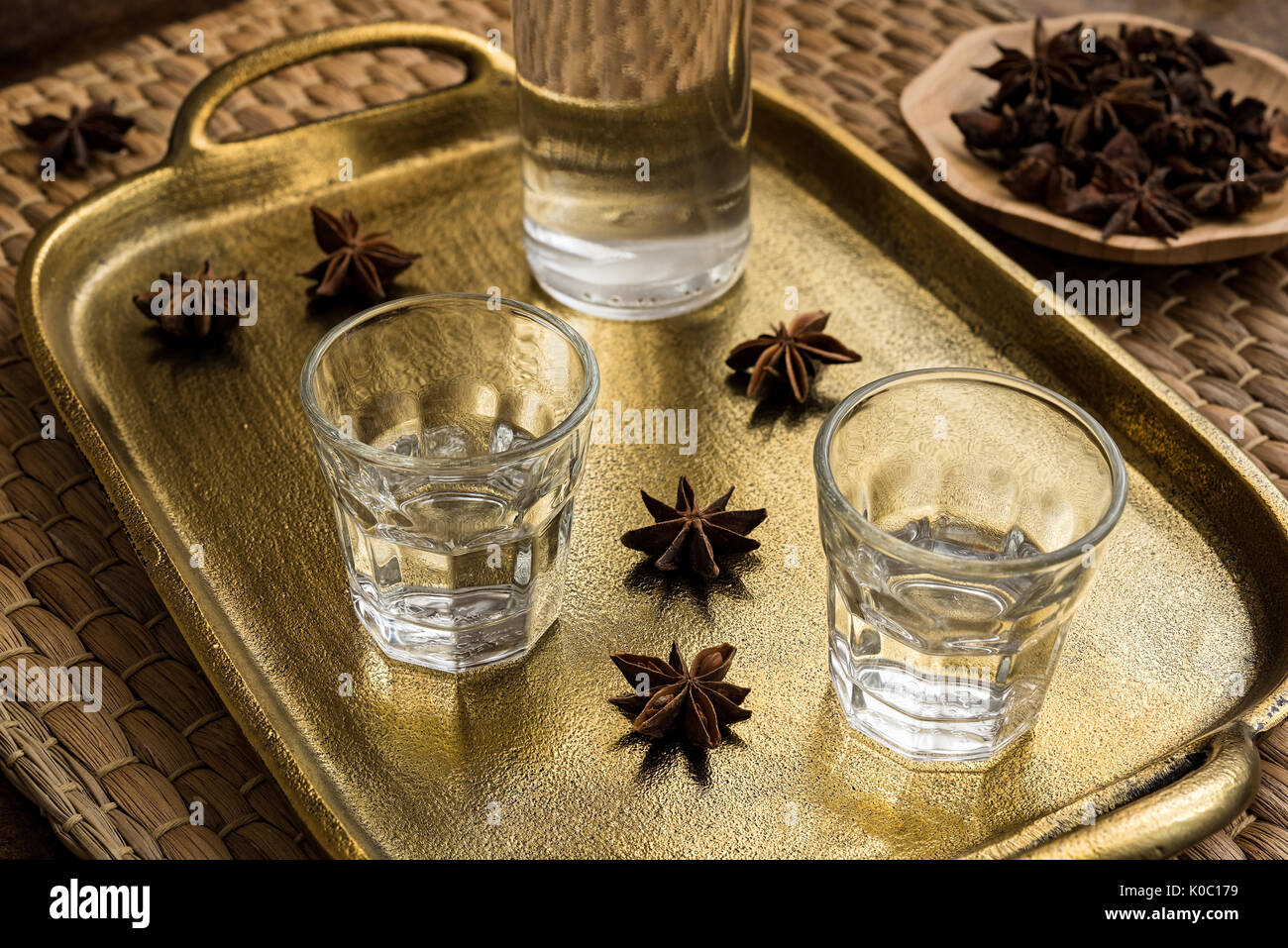 Glasses of traditional drink Ouzo or Raki on bronze dish with anise ...