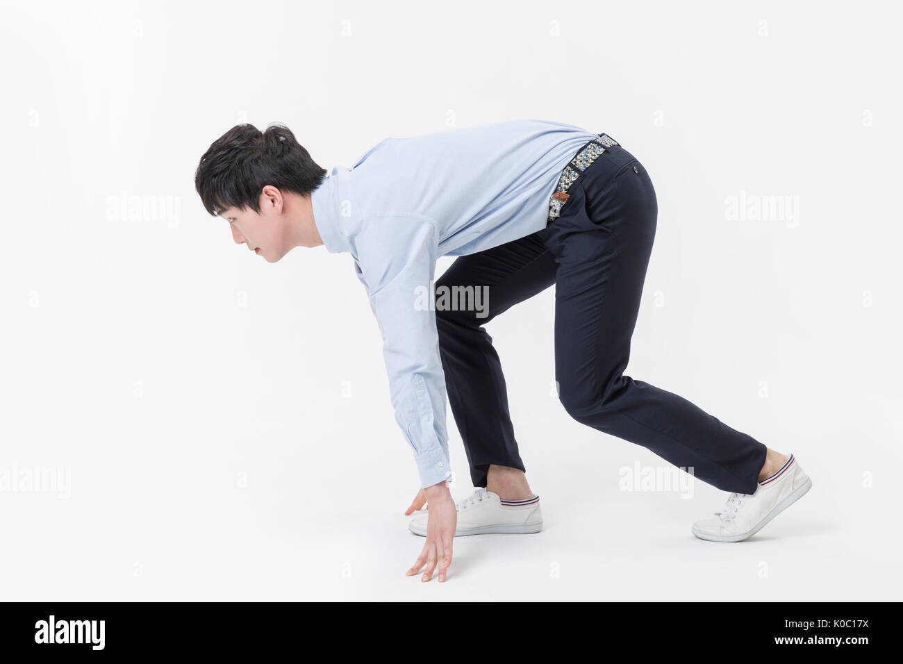 Side view of young man ready to run Stock Photo - Alamy