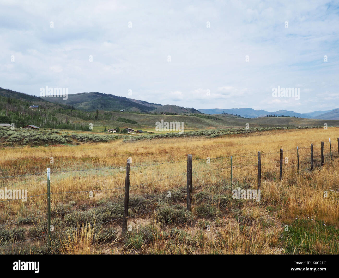 prairie and a simple wire fence in Colorado with hills in the ...