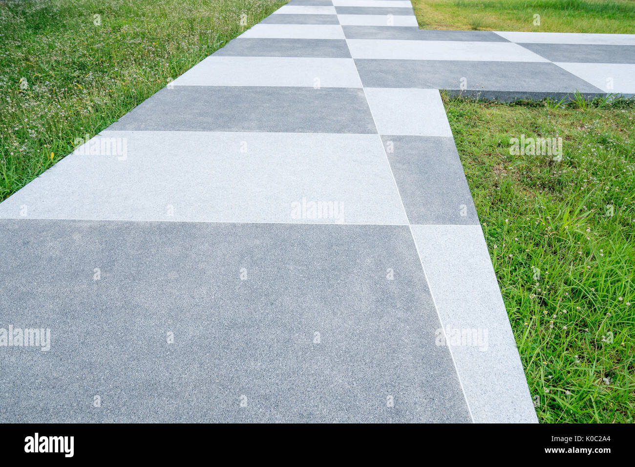 Chess concrete pathway and green grass Stock Photo - Alamy