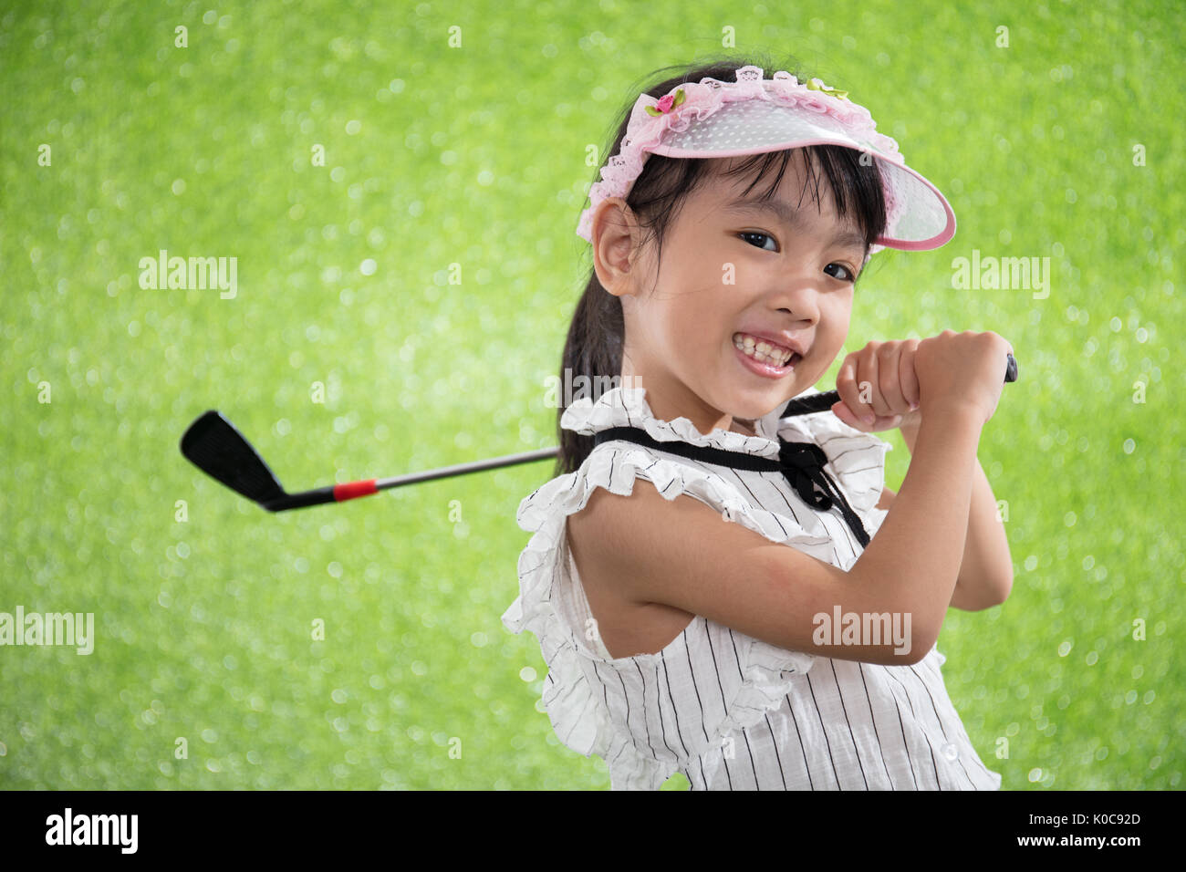 Asian Chinese little girl playing golf on green grass Stock Photo - Alamy