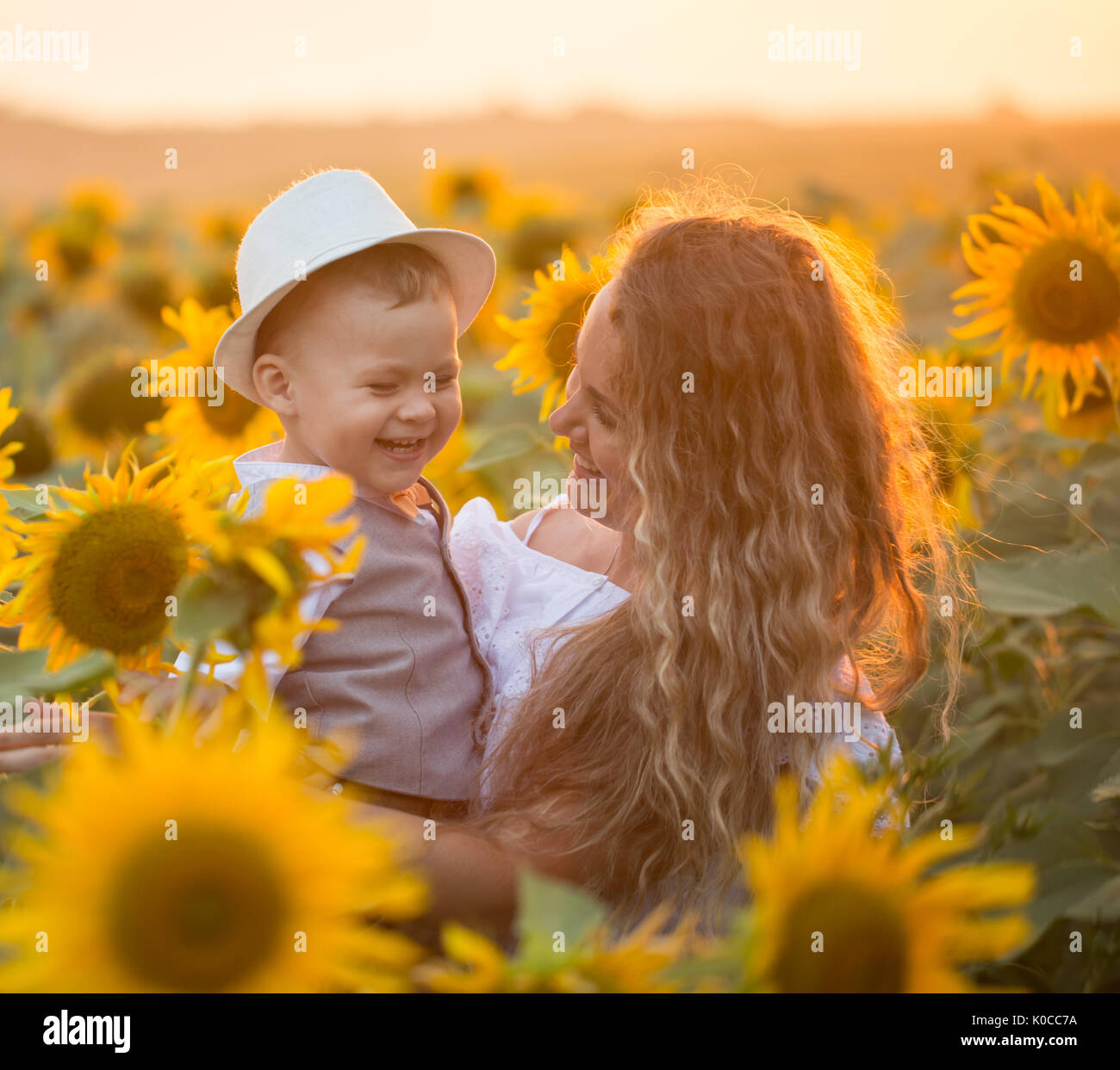 Mother with baby son in sunflower field Stock Photo - Alamy