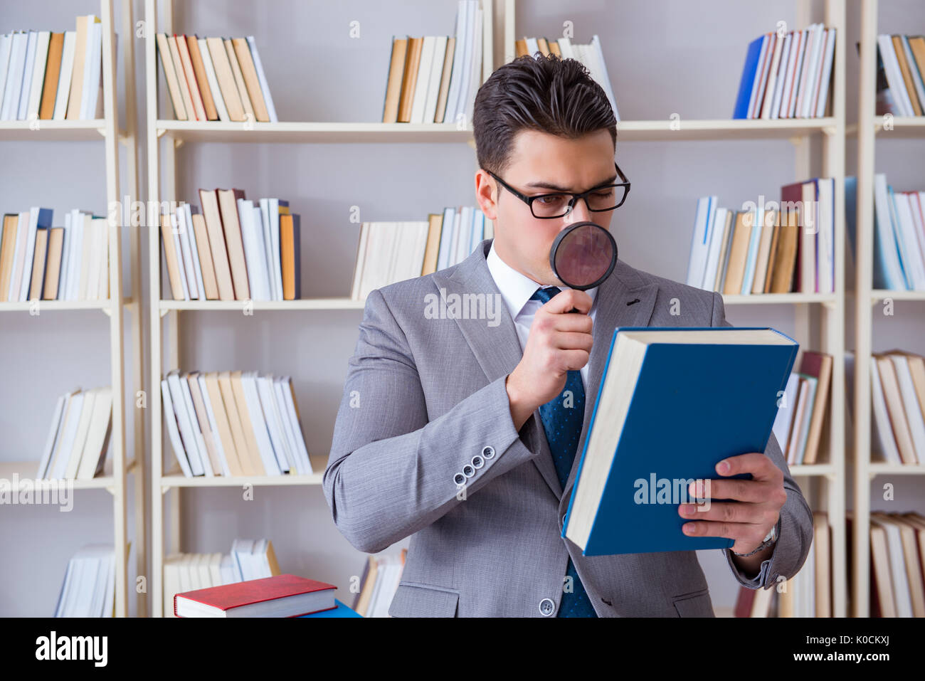 Business law student with magnifying glass reading a book Stock Photo ...