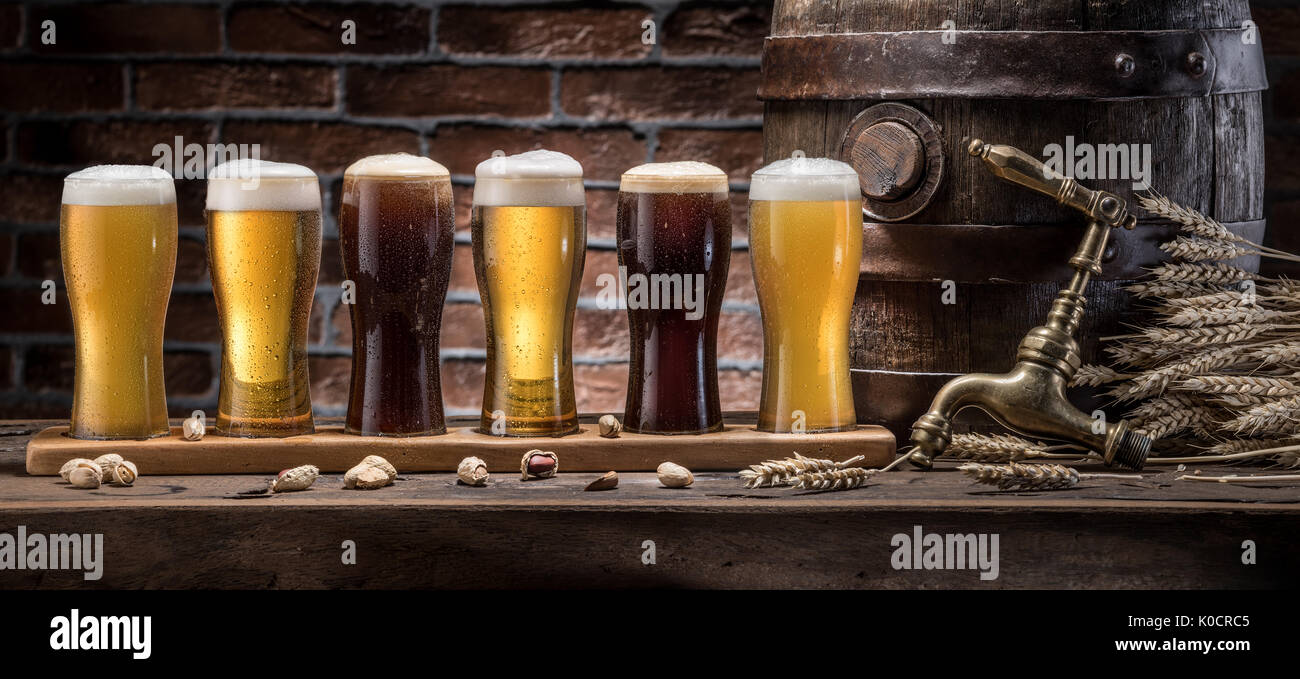 Glasses of beer and ale barrel on the wooden table. Craft brewery Stock ...