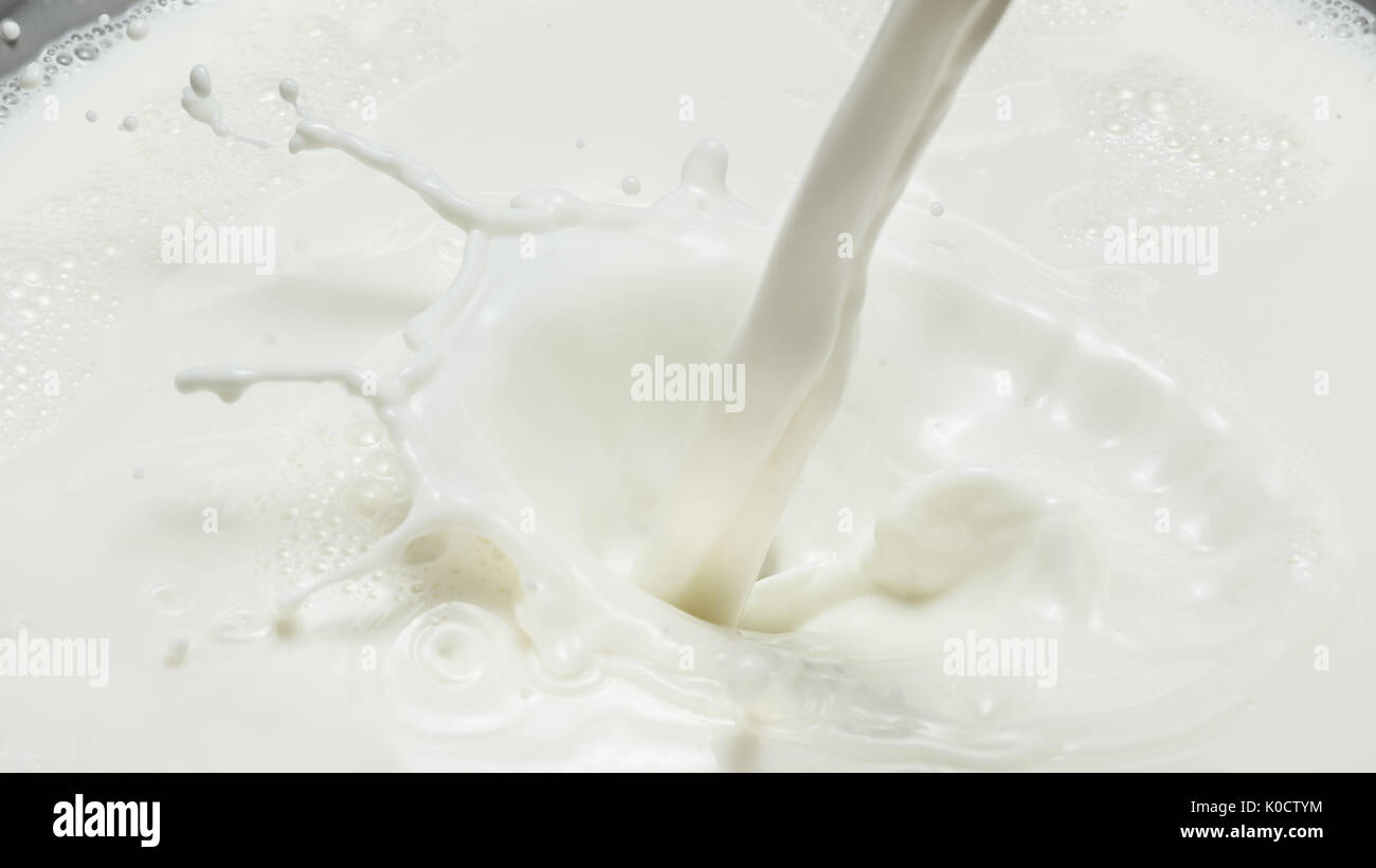 Pouring milk and milk splash. Close-up Stock Photo - Alamy