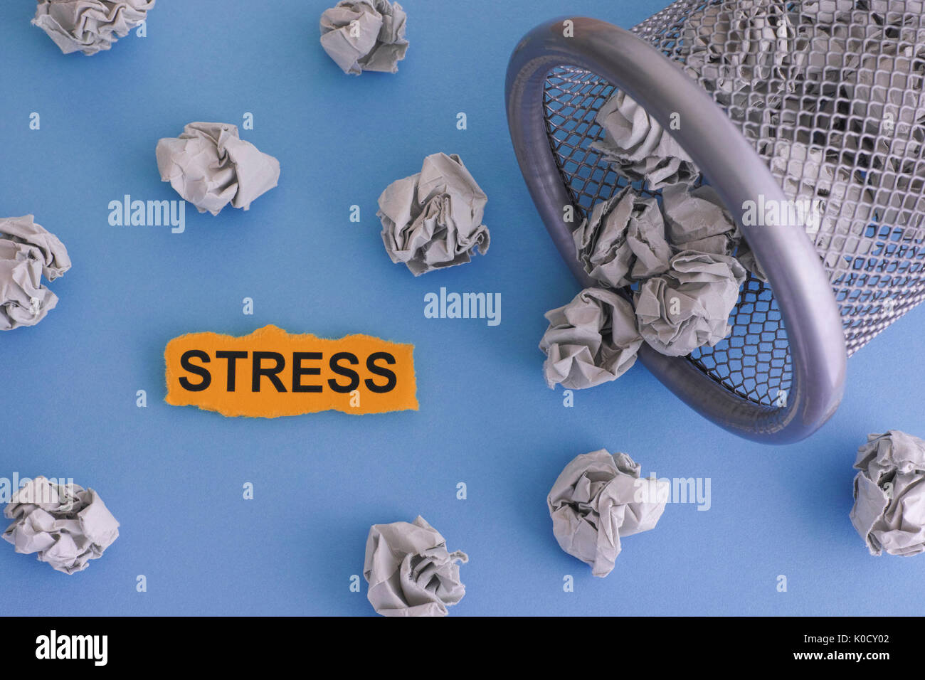Stress. Grey crumpled paper balls rolling out of a trash can. Close up ...
