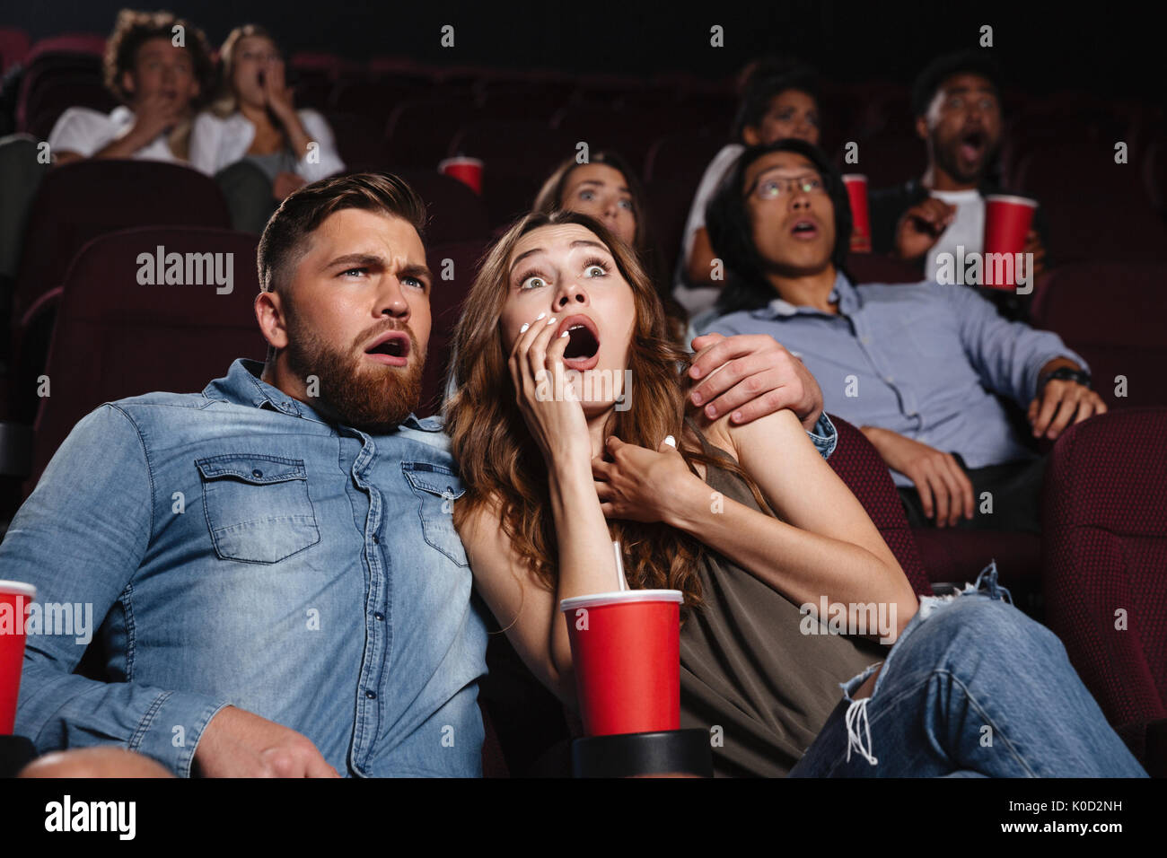 Shocked young couple watching a horror movie at cinema Stock Photo - Alamy