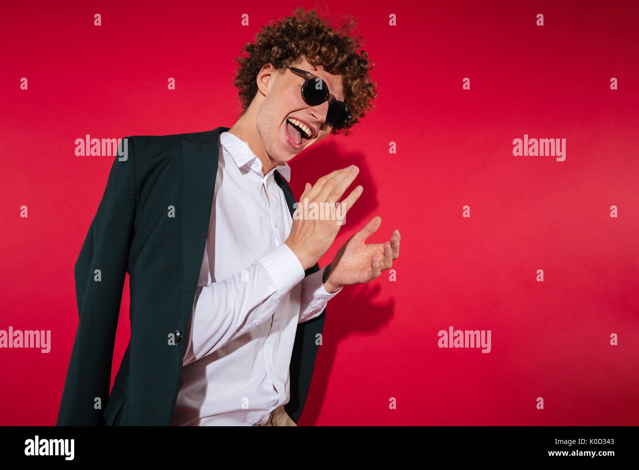 Happy excited young man in white shirt and jacket celebrating success ...