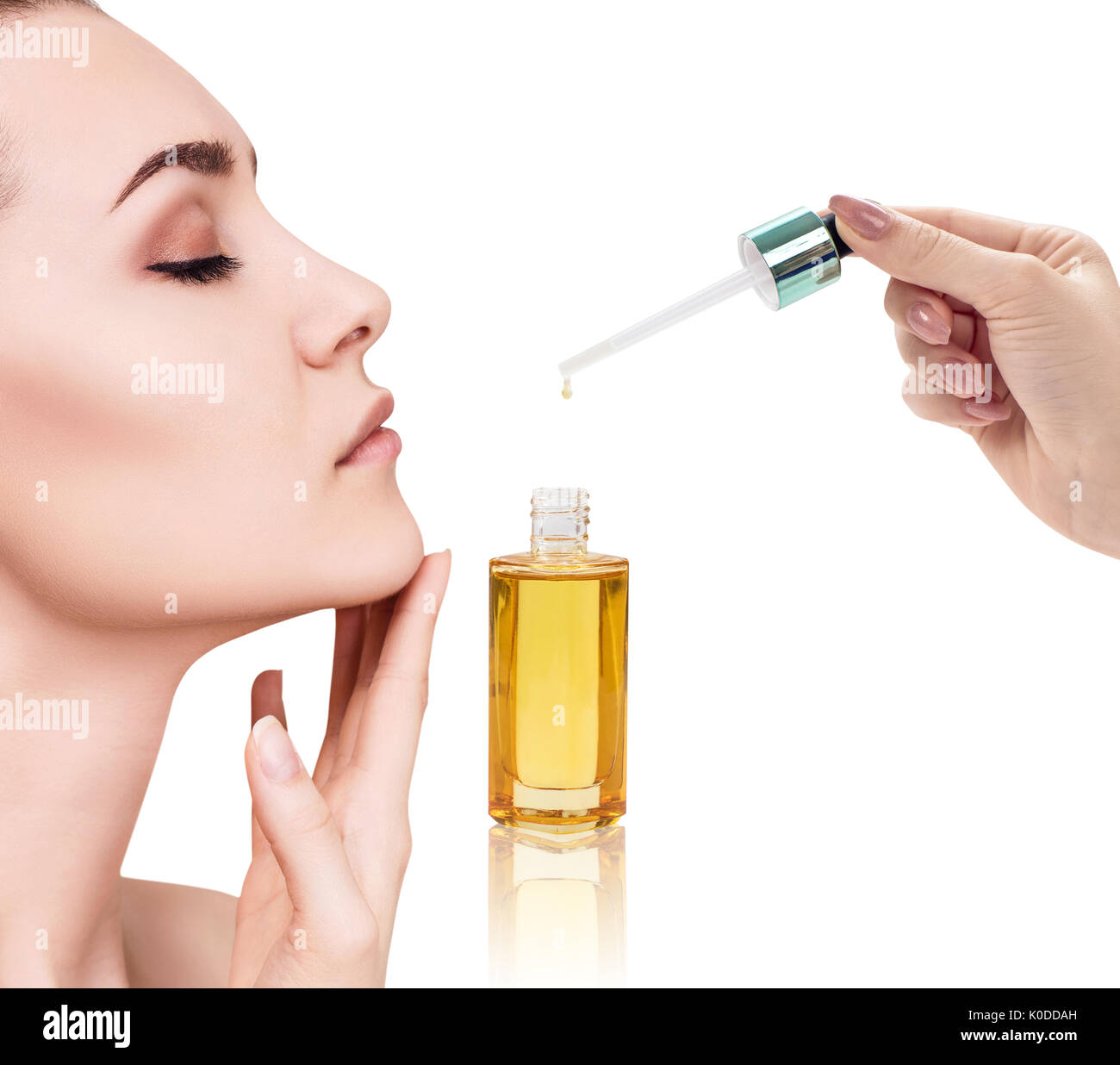 Cosmetic oil applying on face of young woman Stock Photo - Alamy