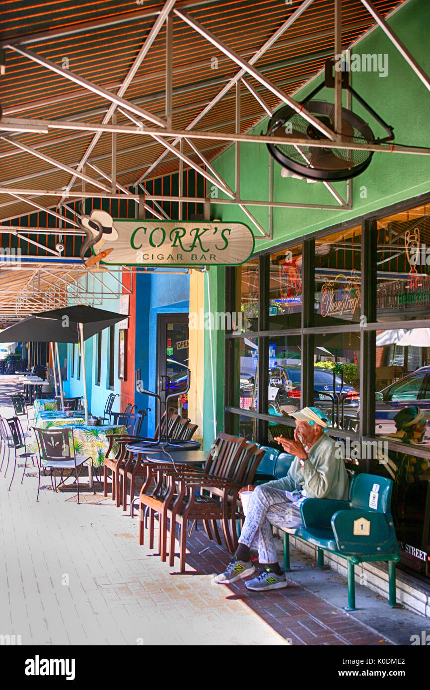 Old man sitting smoking a cigar outside Cork's Cigar Bar in Old Main ...