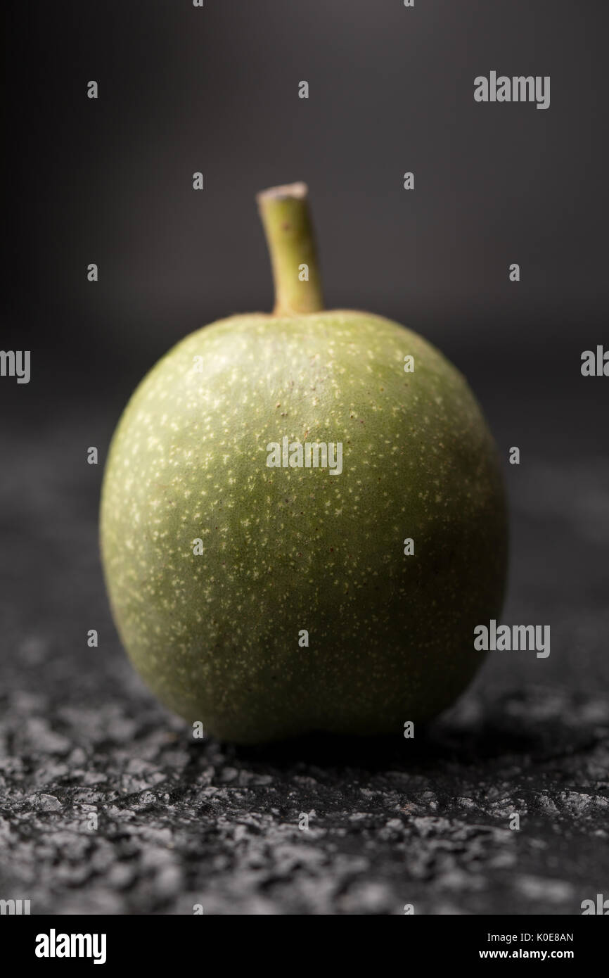 A fresh green walnut in the peel is fresh from the tree. Walnut on a ...