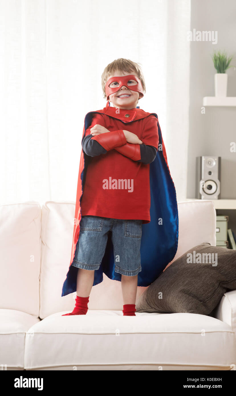 Little superhero boy standing on sofa and posing like a real hero Stock ...
