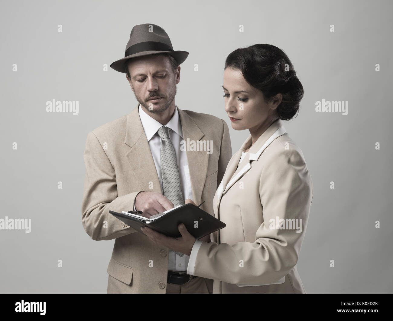 Vintage manager and secretary working together checking notes and ...