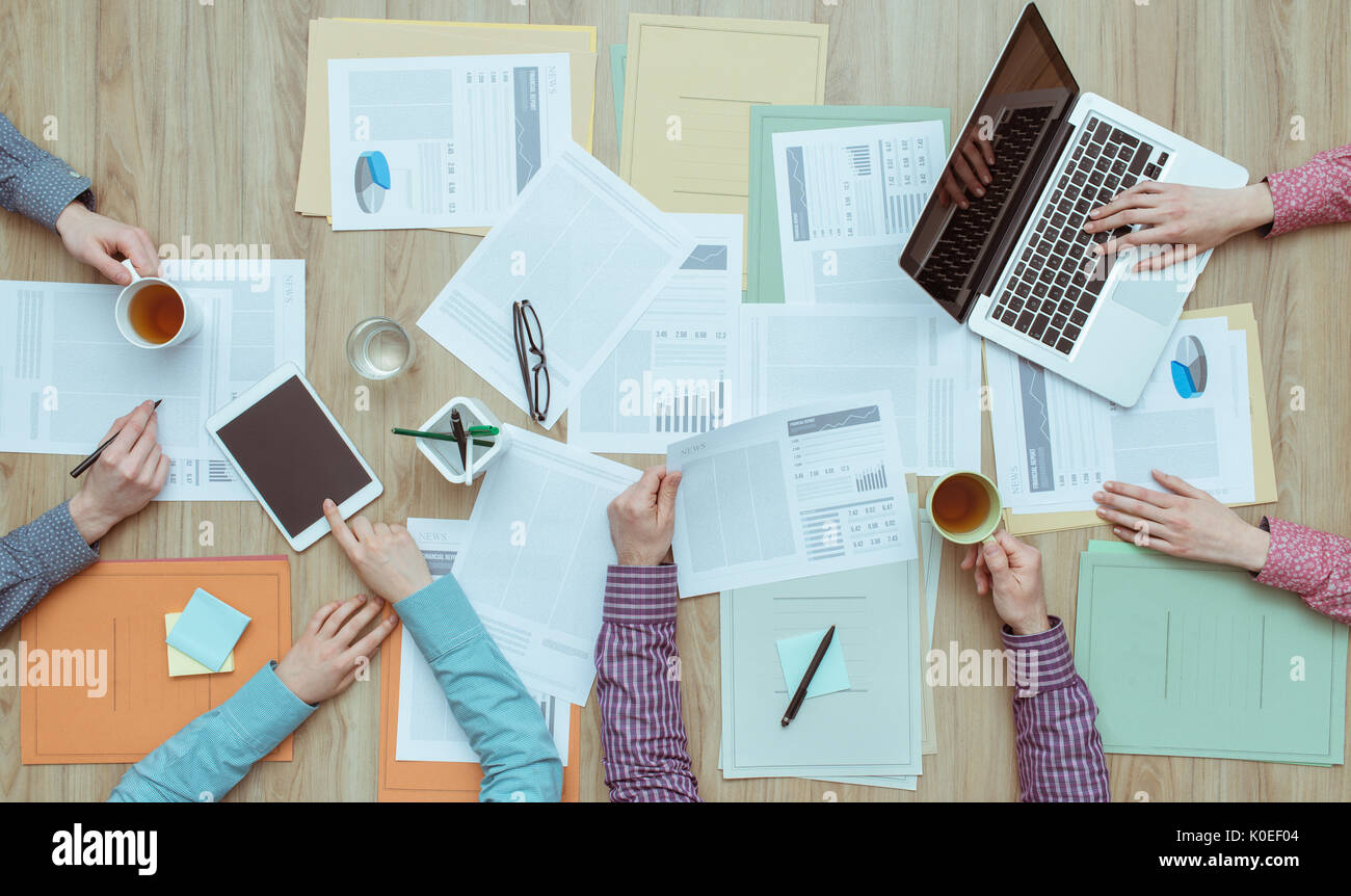 Business team working at office desk with paperwork, a laptop and a ...