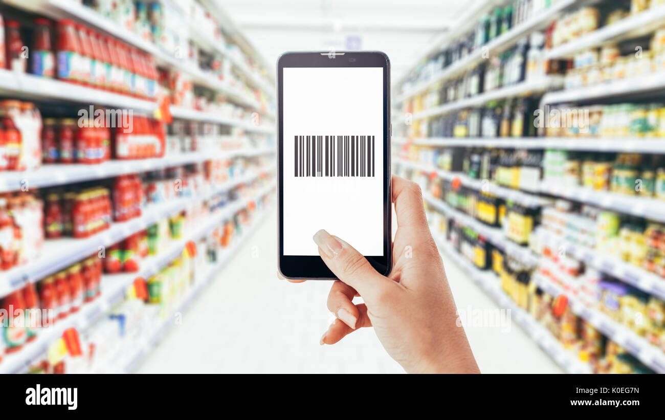 Woman doing grocery shopping at the supermarket and scanning a barcode ...