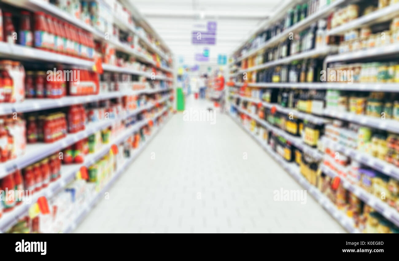 Defocused supermarket aisle with store shelves and unrecognizable ...