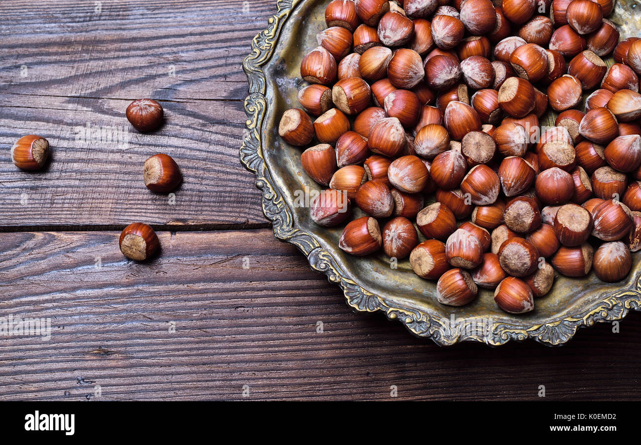 Hazelnuts on an iron plate, empty space on the left Stock Photo - Alamy