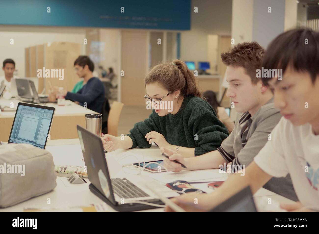 College students sit at a table studying in the Brody Learning Commons ...