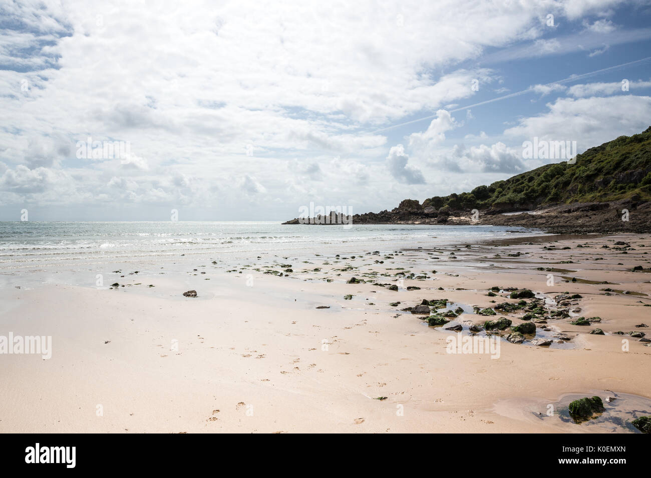 A coastal scene with sea, sun sand and rock at Pwlldu Bay on the Gower ...