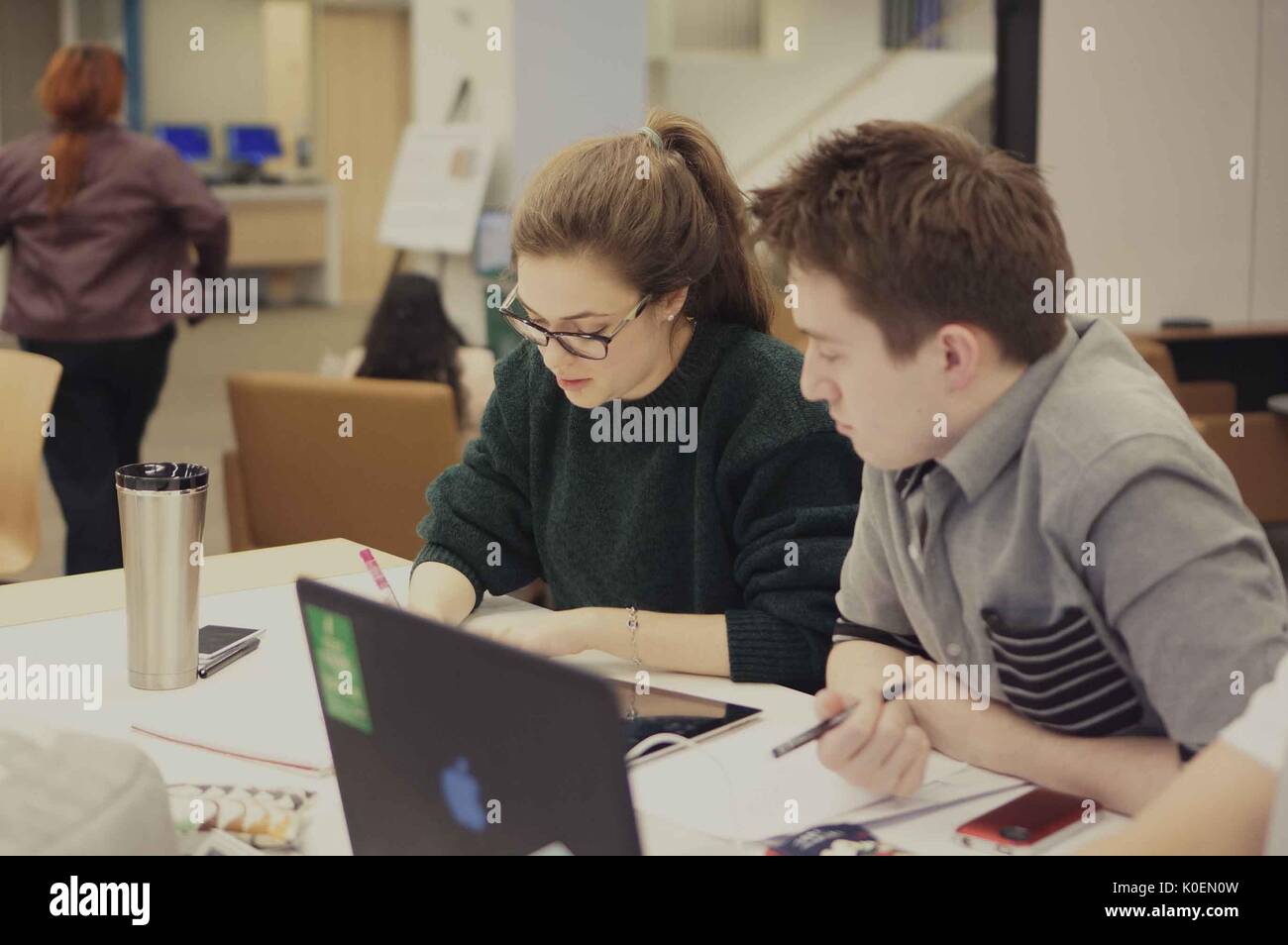 College students sit at a table, studying together in the Brody ...