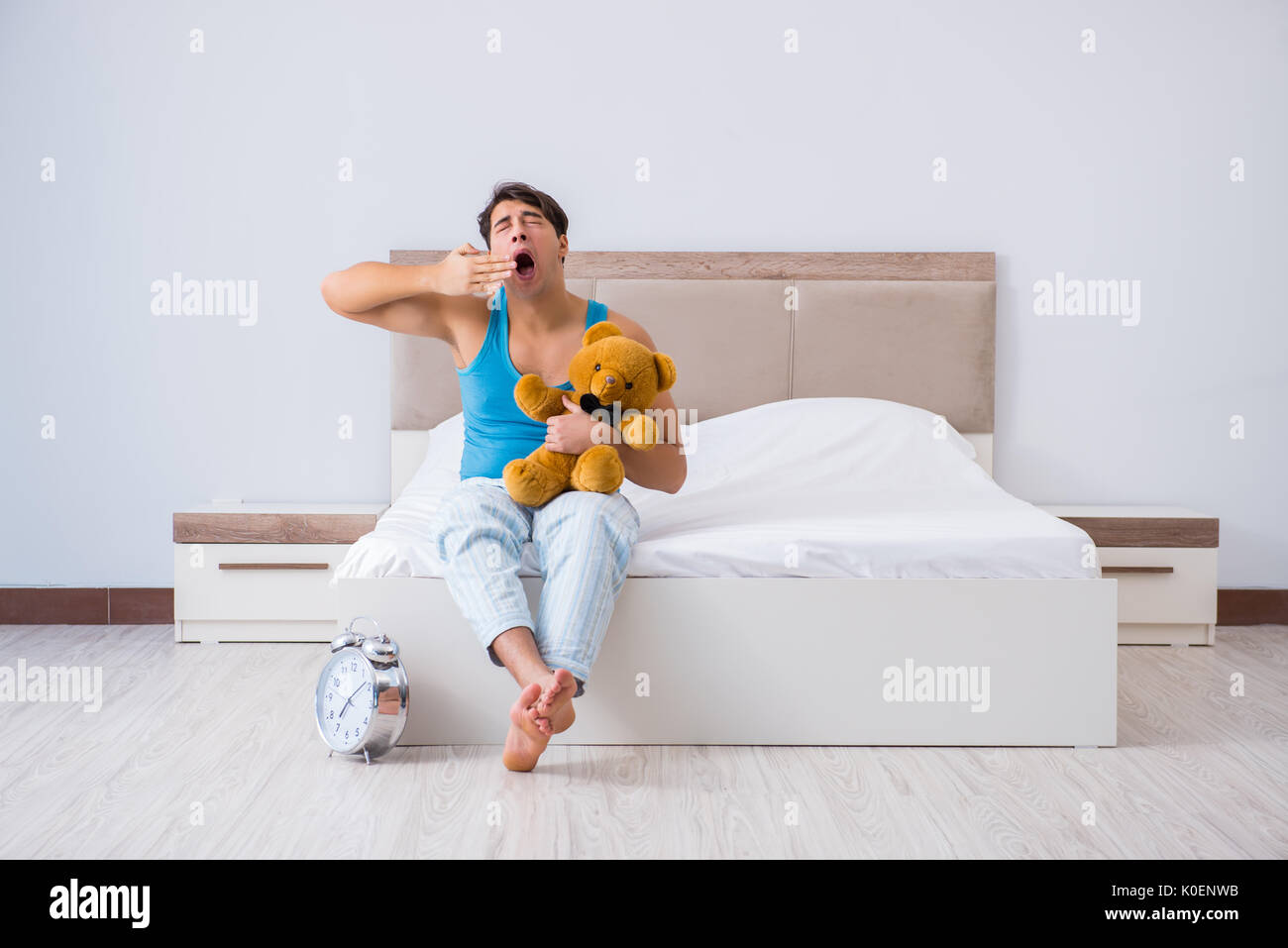 Young man waking up in bed Stock Photo - Alamy