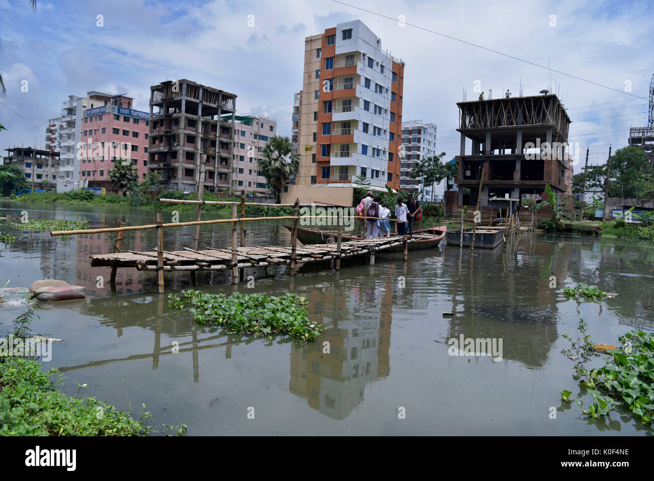 Dhaka, Bangladesh. 23rd Aug, 2017. Bangladeshi people using a half made makeshift bamboo bridge ...