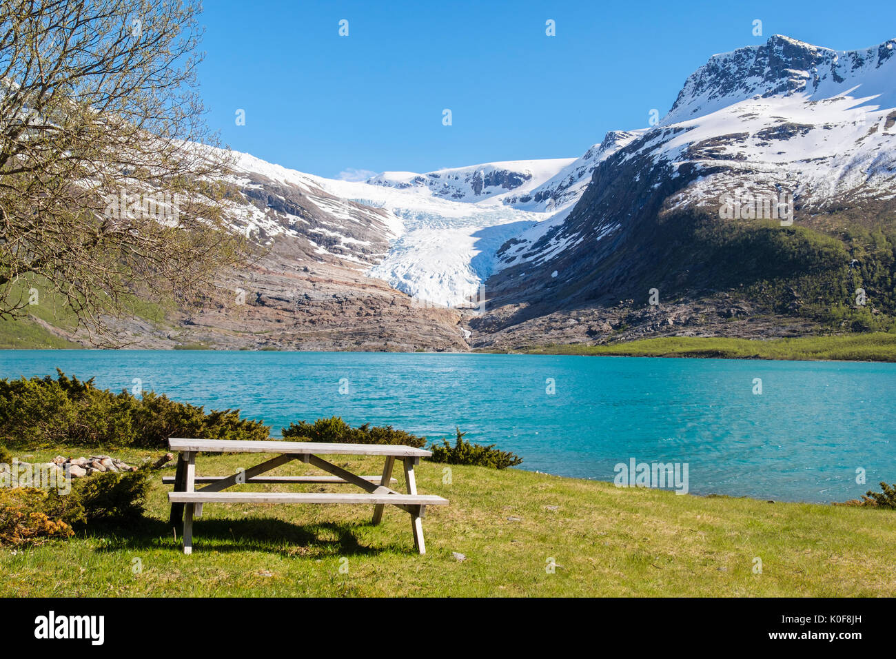Picnic table by Engabreen Enga glacier arm of Svartisen ice cap across ...