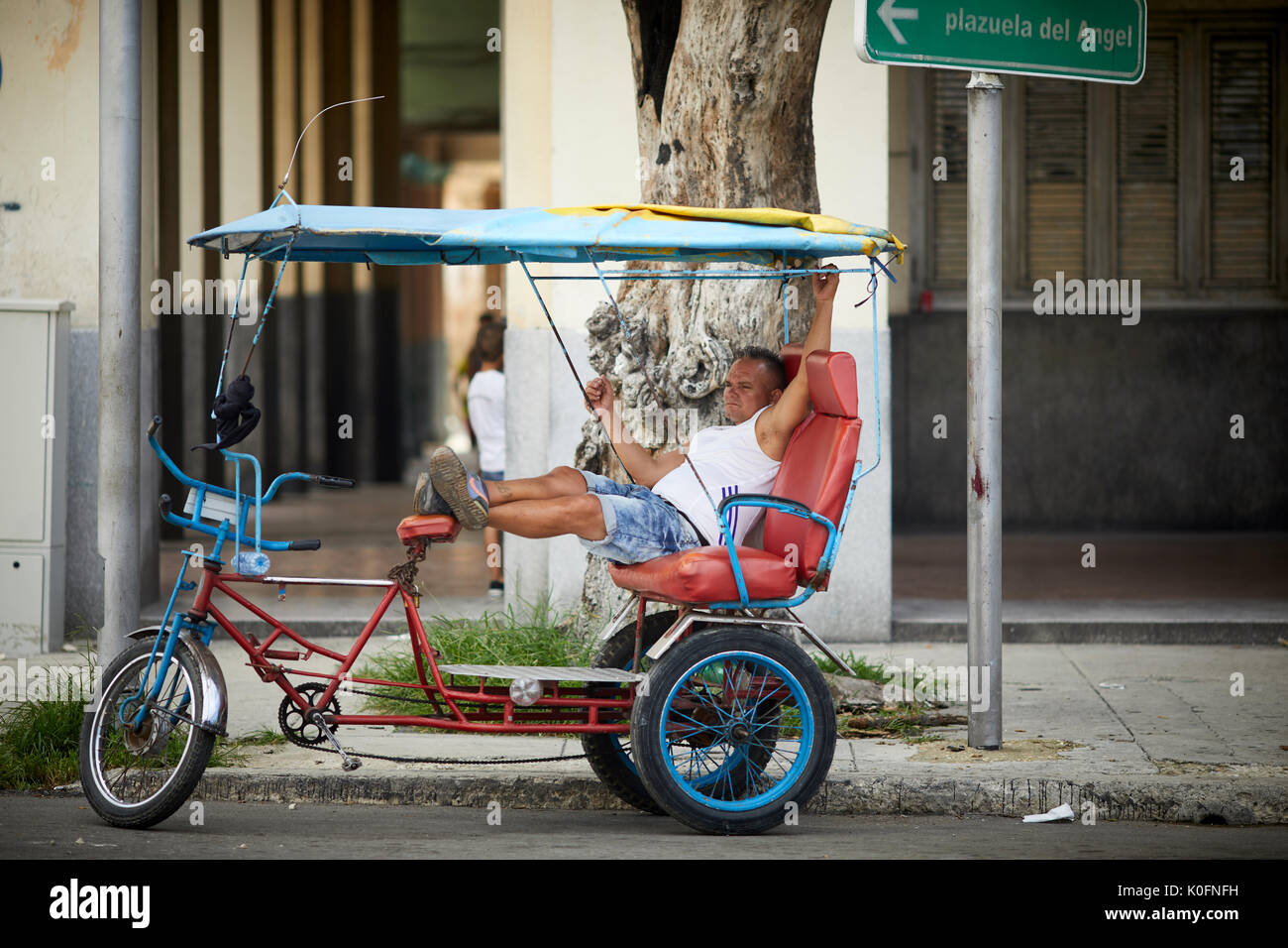 Cuban, Cuba, Capital, Havana driver resting between rides 3 wheeled ...