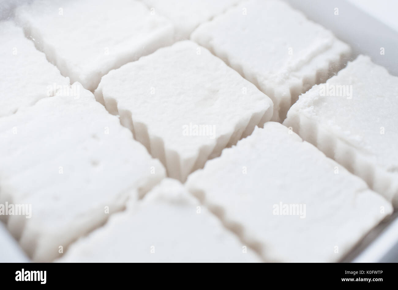 Square marshmallows in a box on a white background Stock Photo - Alamy