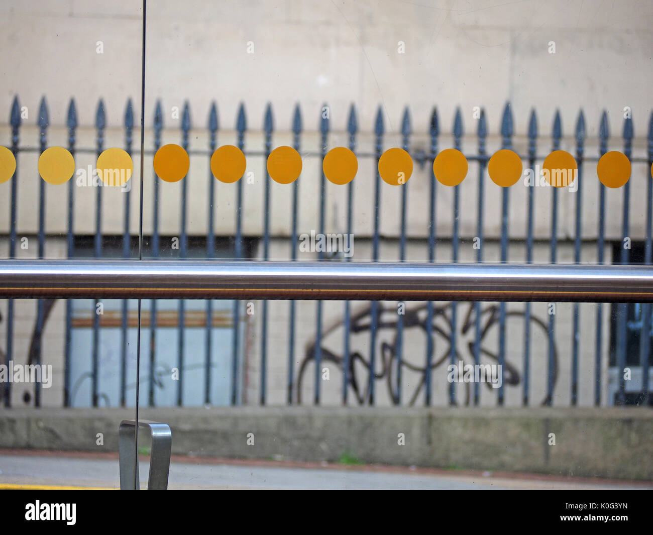 seen through steel hand-rail and yellow spots on the glass panel of a ...