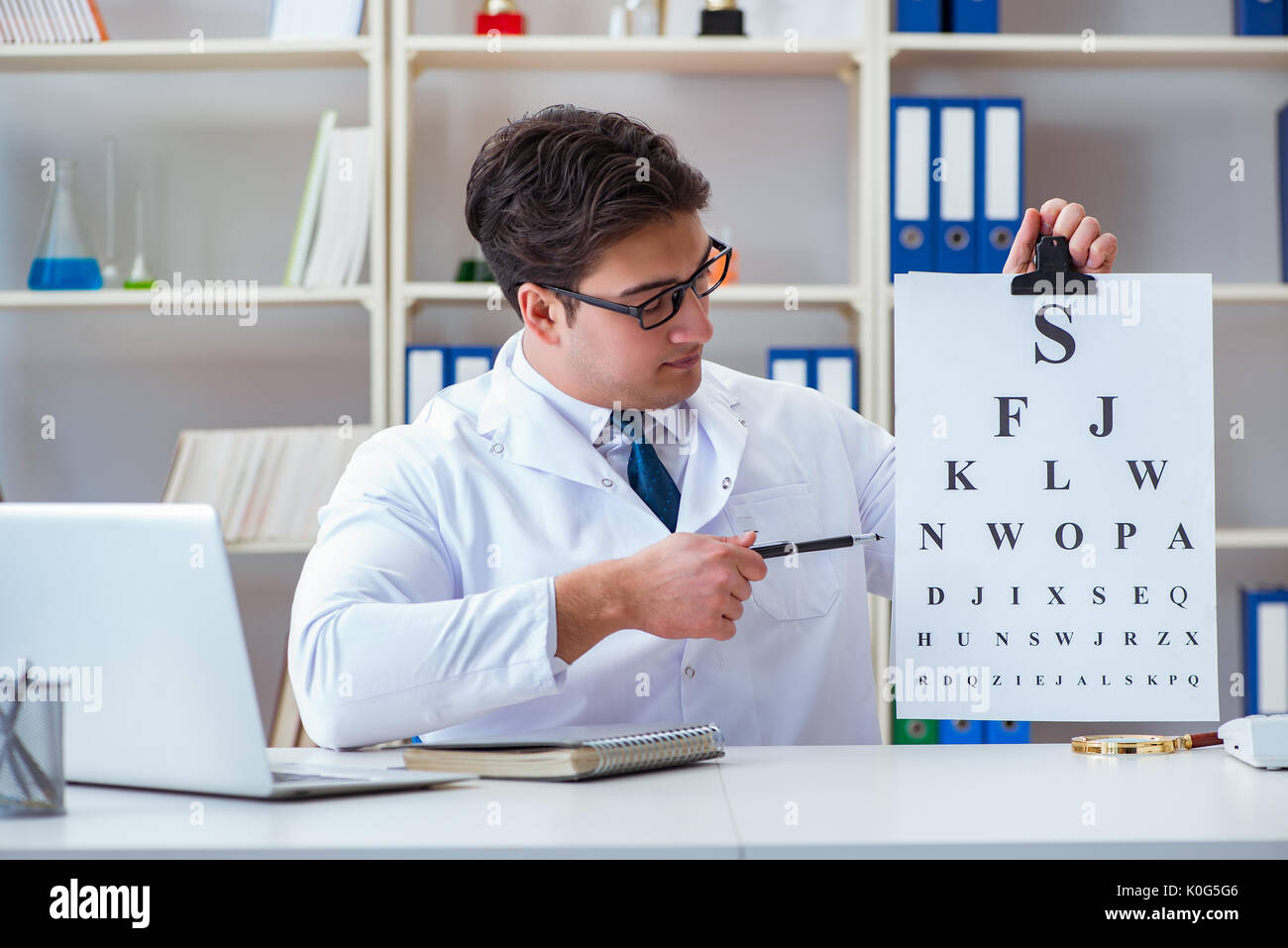 Doctor optician with letter chart conducting an eye test check Stock ...