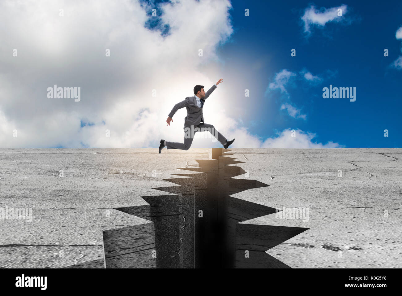 Businessman jumping over the cliff Stock Photo - Alamy