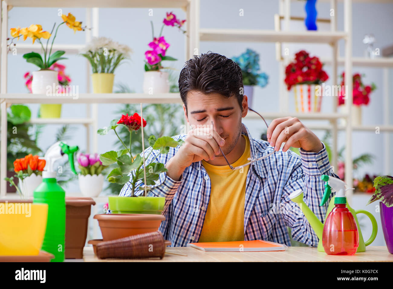 Young man florist working in a flower shop Stock Photo - Alamy