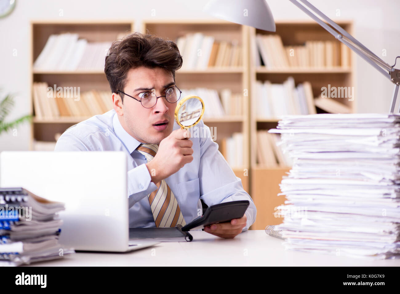 Mad auditor looking for errors in the report Stock Photo - Alamy