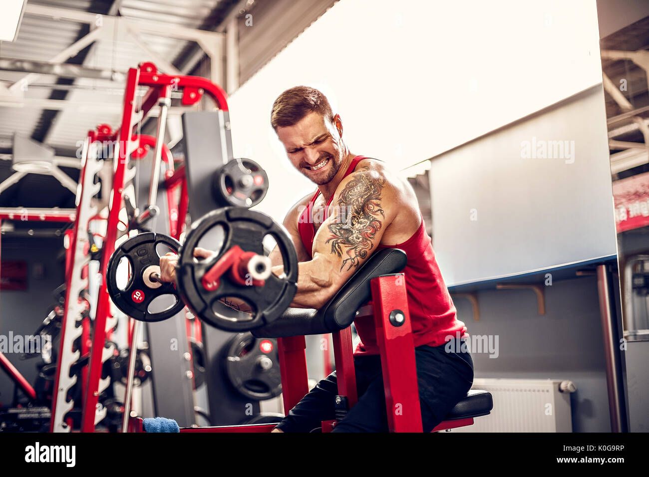 Man bodybuilder doing the set of a barbell exercise in a gym. Real time ...