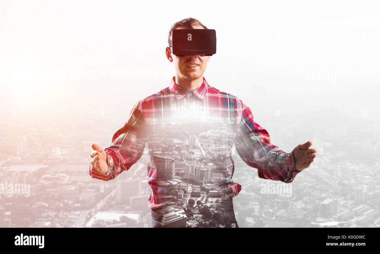 Guy wearing checked shirt and virtual mask stretching hands and trying ...