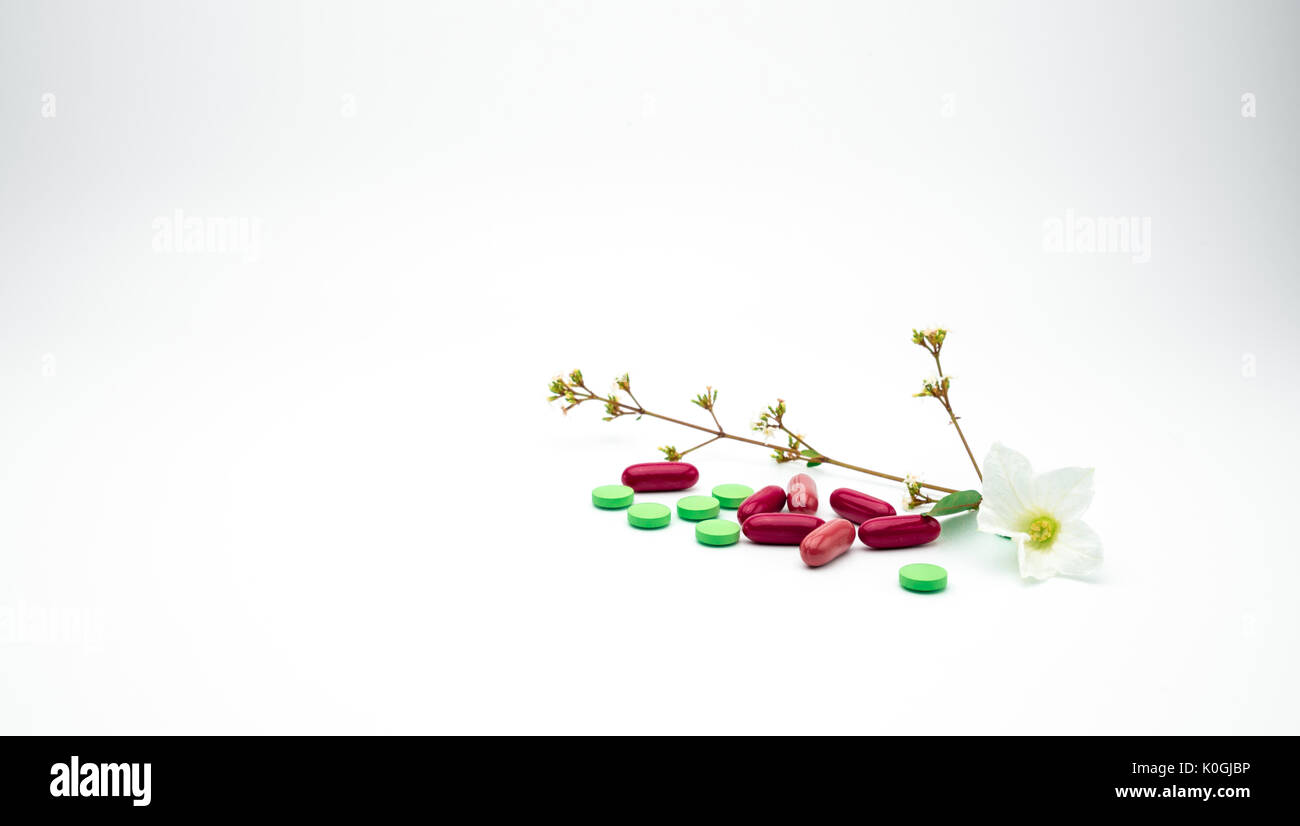 Red, green vitamin and supplement tablet and capsule pills with flower ...