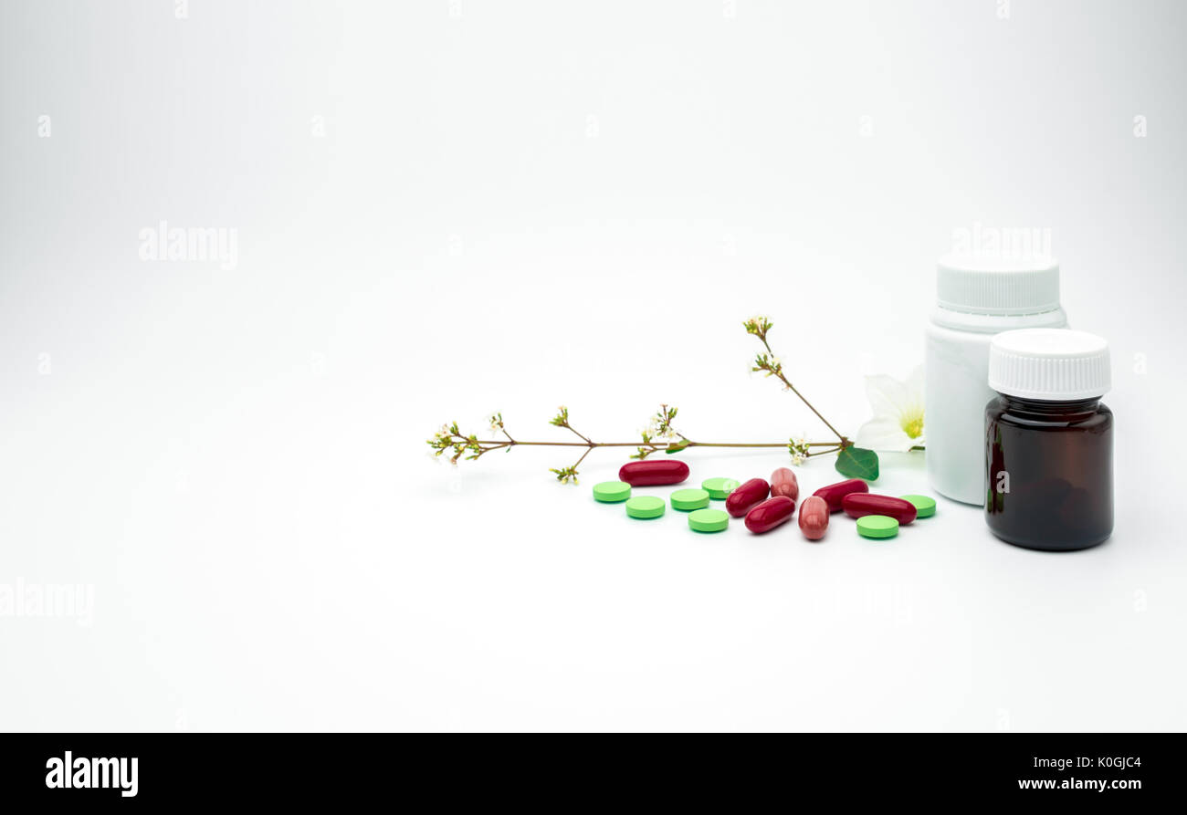 Red, green vitamin and supplement tablet and capsule pills with flower ...