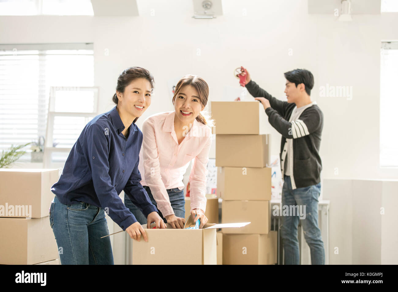 Smiling business people packing delivery boxes Stock Photo - Alamy