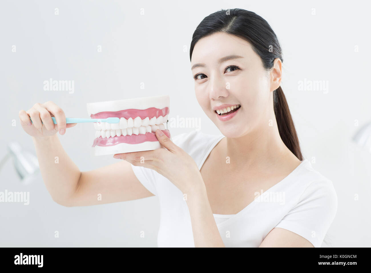 Portrait of smiling woman showing how to brush teeth correctly Stock ...